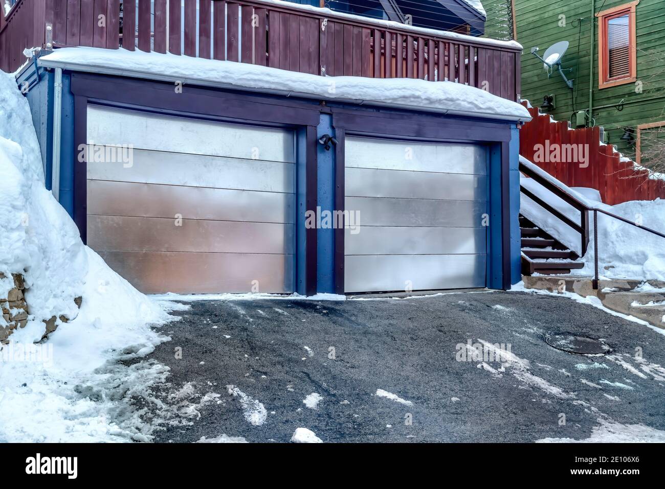 Two car garage of home with shiny metal doors under the deck with ...