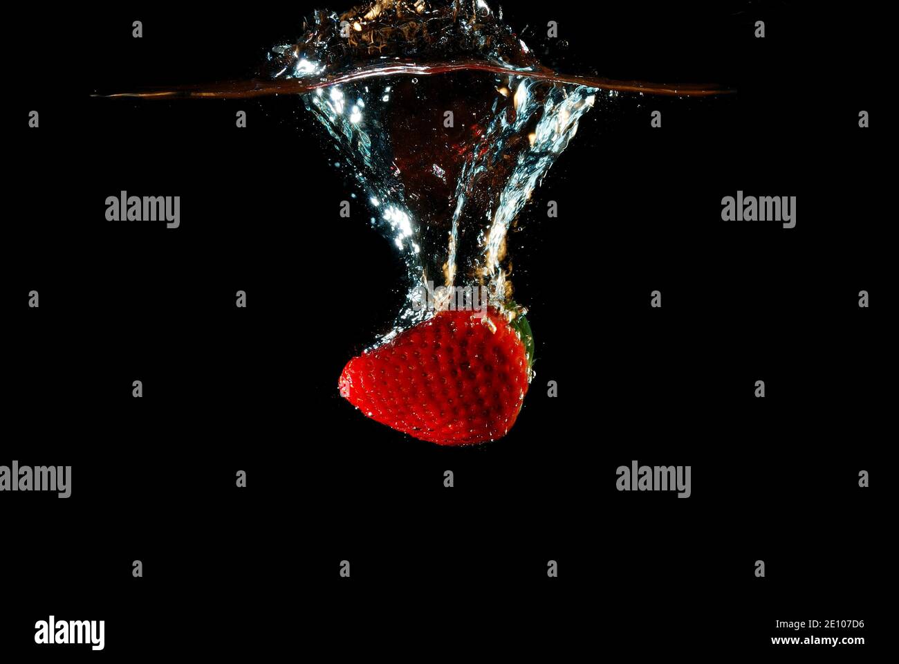 fresh red strawberry falling into water making a wave Stock Photo - Alamy