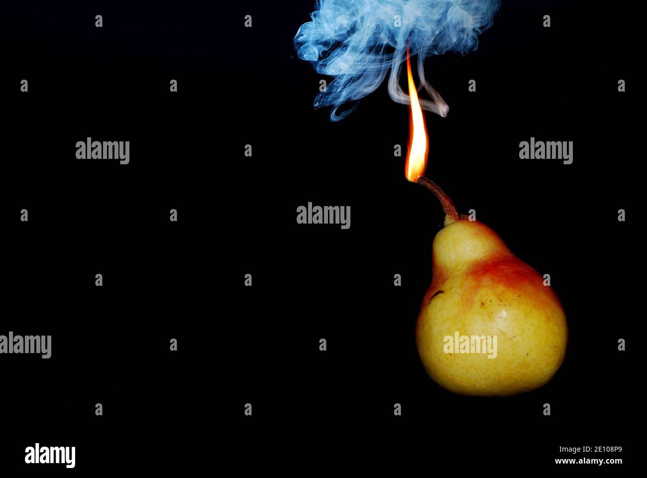 pear with a flame and gray smoke on black background Stock Photo - Alamy
