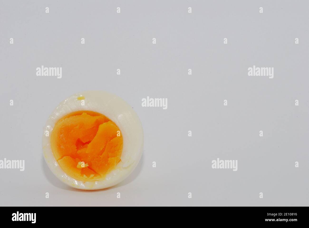 orange egg with yolk on white background left Stock Photo - Alamy