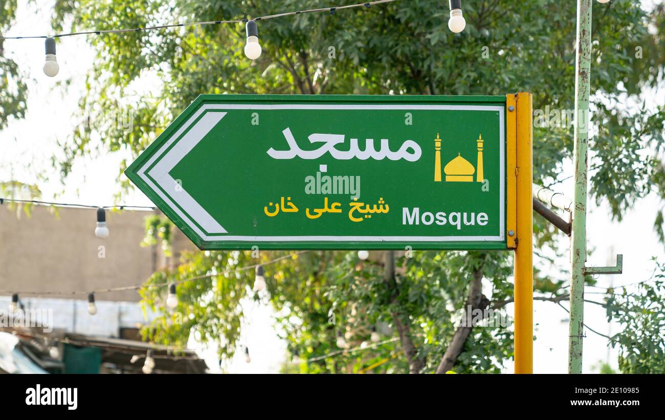 Street sign indicating the direction to a Muslim mosque in Iran. Arabic ...
