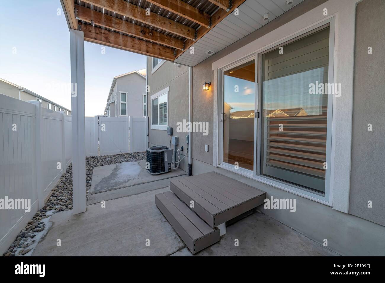 Sliding glass door and wooden steps at the back of a home with wooden ...