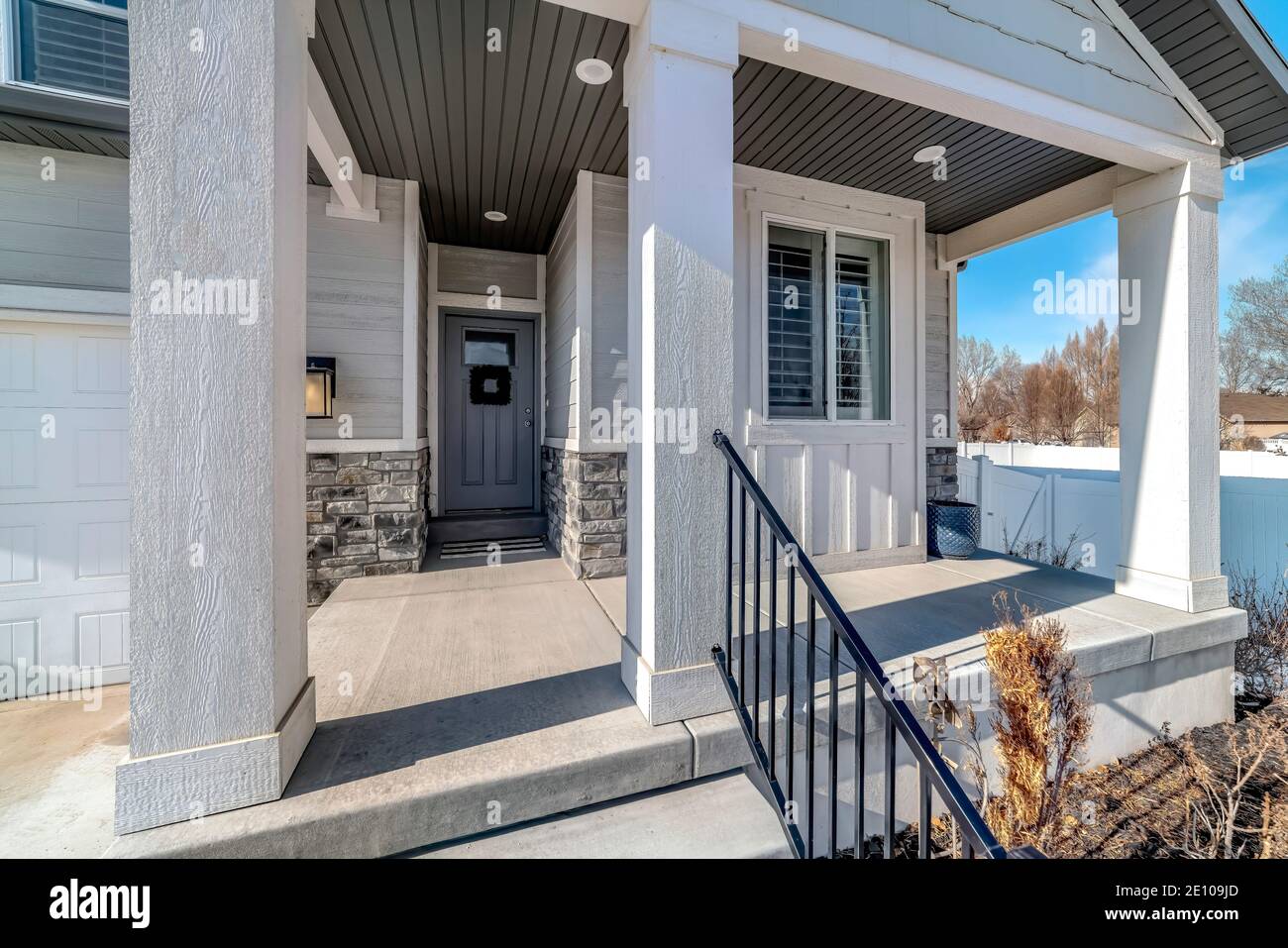Front view of a lovely home with stairs and porch in front of gray ...