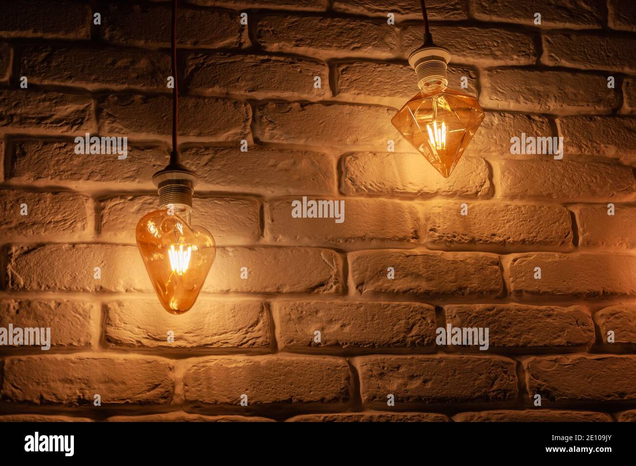 Old lighting electric bulb, Retro lamp on a background of a white brick ...