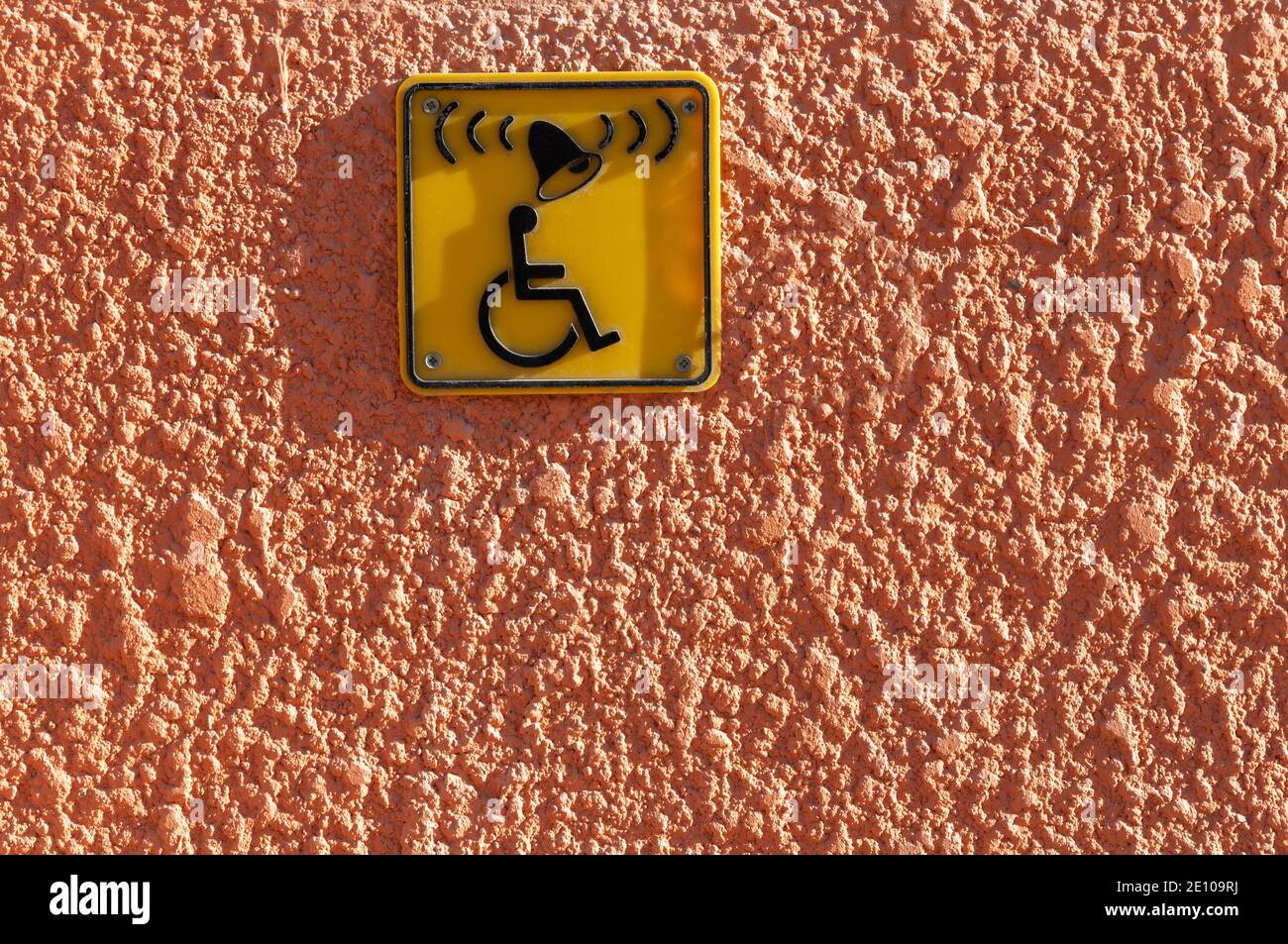 Invalid on wheelchair and ring bell sign on the wall. Disabled people ...