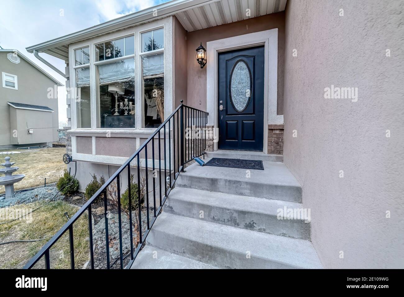 Front view of a house with stairs going up to front door with oval ...