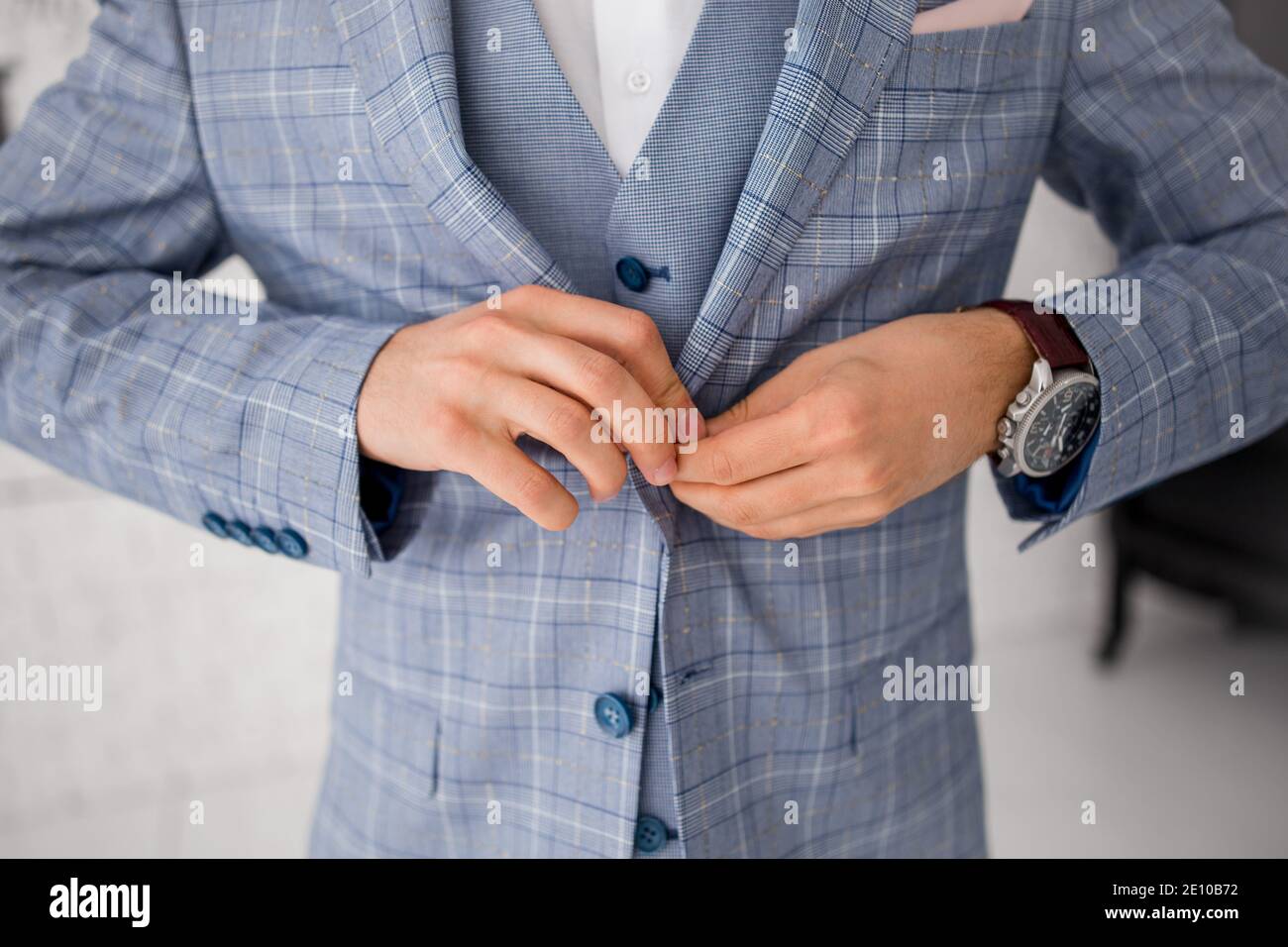 man buttons up the buttons of a blue suit jacket Stock Photo - Alamy