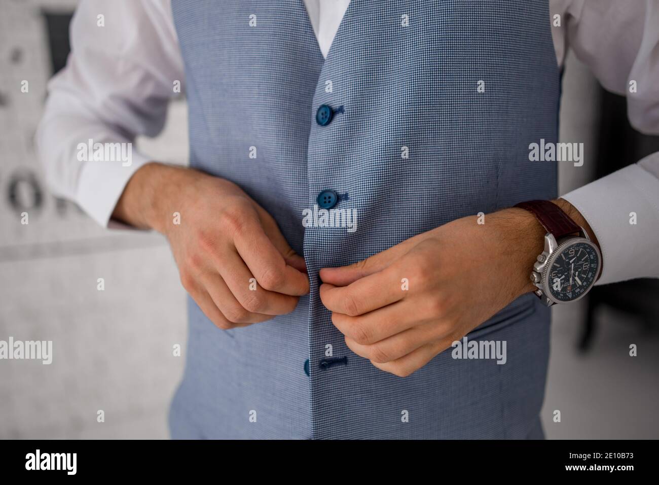 man buttons up the buttons of a blue suit jacket Stock Photo - Alamy
