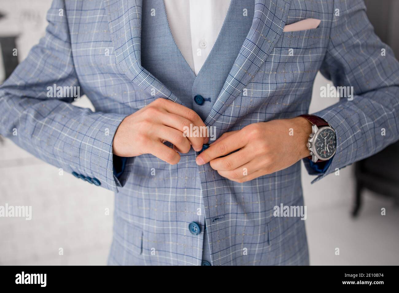man buttons up the buttons of a blue suit jacket Stock Photo - Alamy