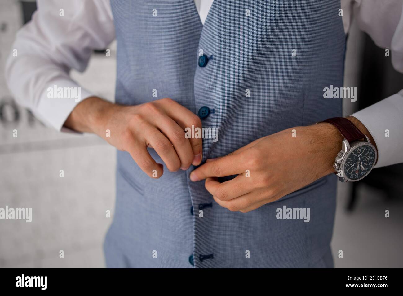 man buttons up the buttons of a blue suit jacket Stock Photo - Alamy