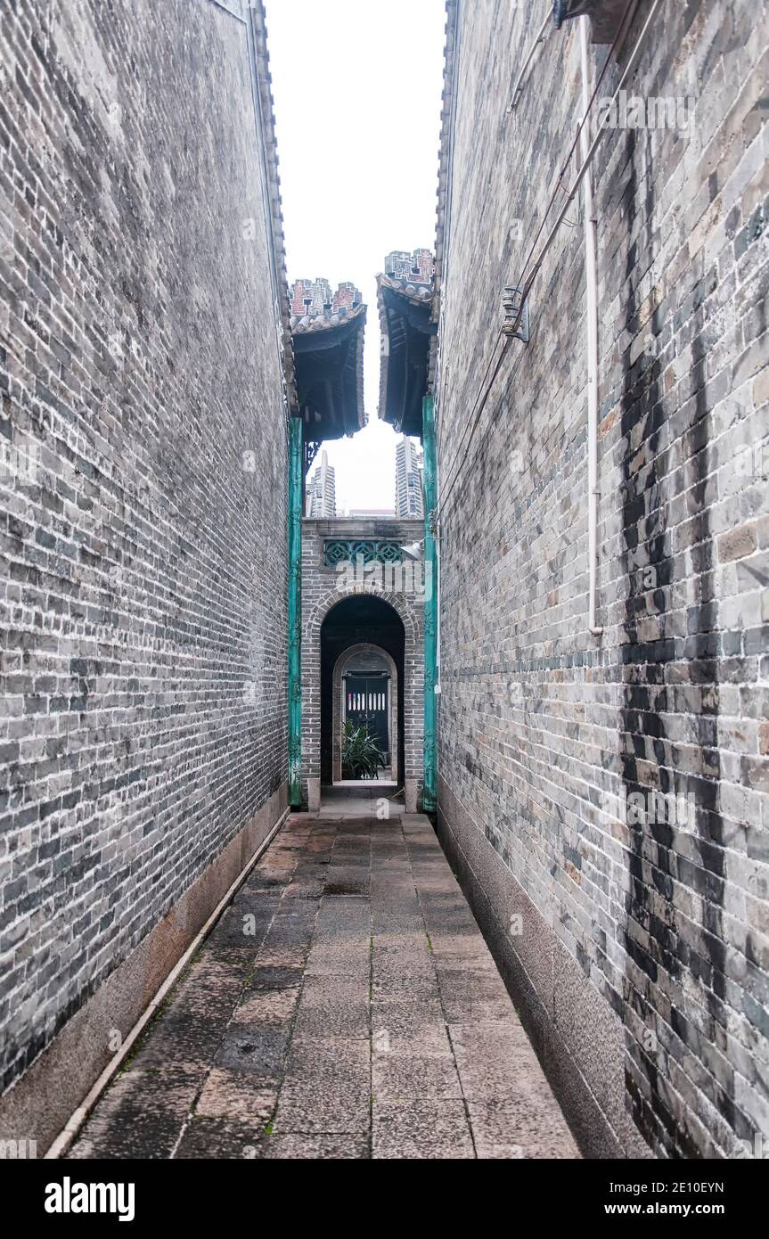 A narrow alleyway leading to an arch and doorway in the huangpu village ...