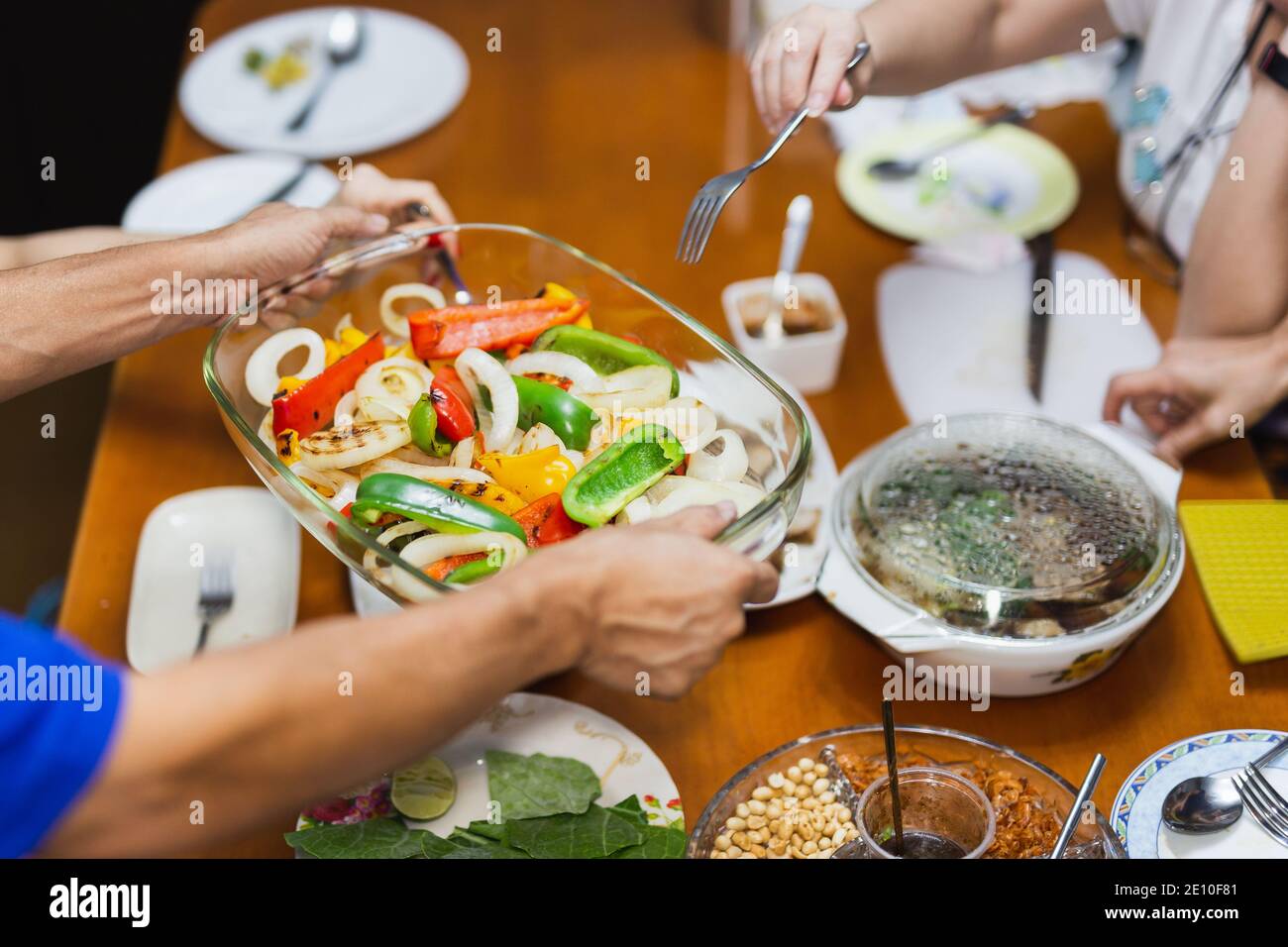 Hand serving mixed vegetables in glass dish on dinner table Stock Photo ...