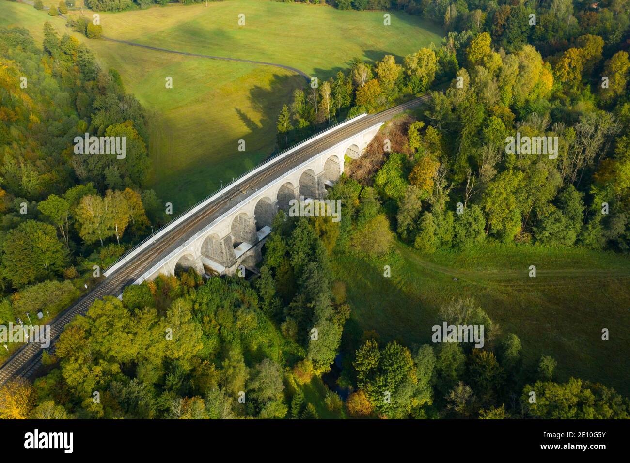 An aqueduct or arched bridge in the terrain with high trees and ...