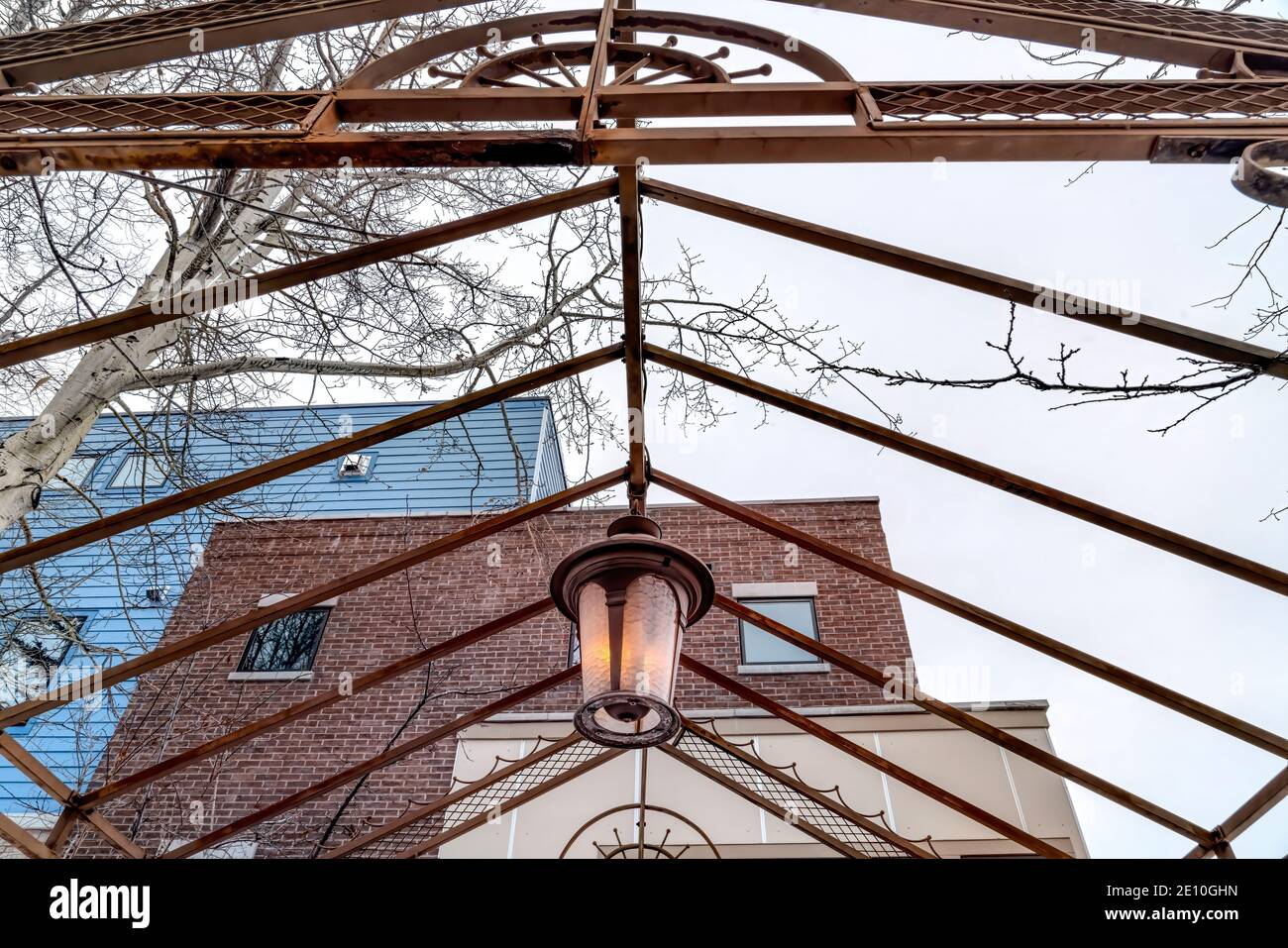 Old vintage outdoor lamp hanging on the rusty metal roof beams of a ...
