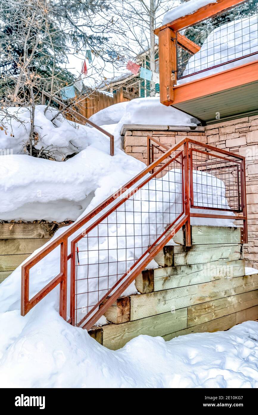 Outdoor stairs of hill home covered with thick layer of snow in winter ...
