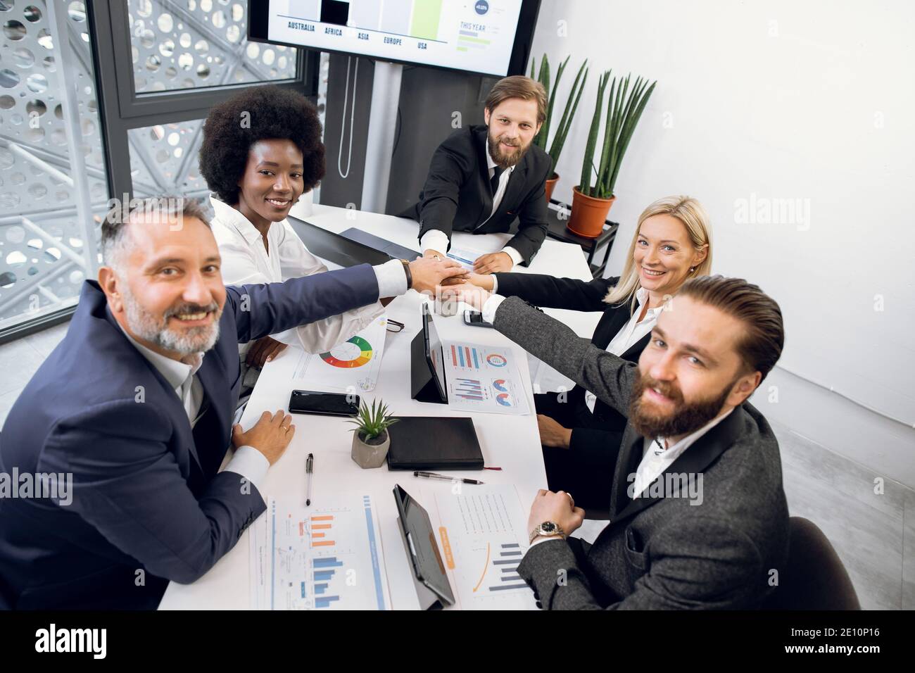 Portrait of team of positive successful multiethnic corporate coworkers ...