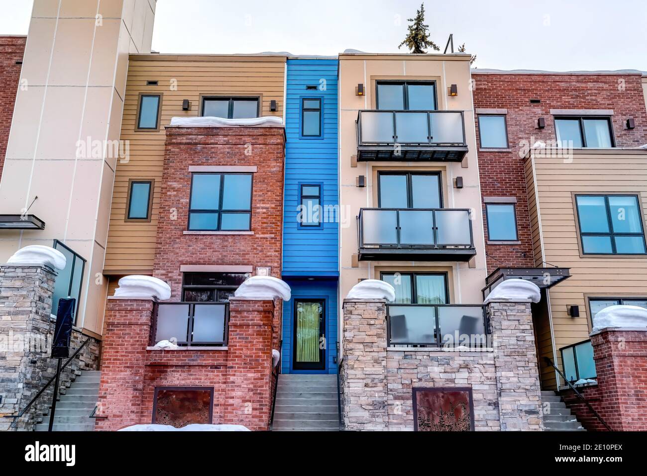Apartment building with snowy flat roof in winter and stairs at front ...