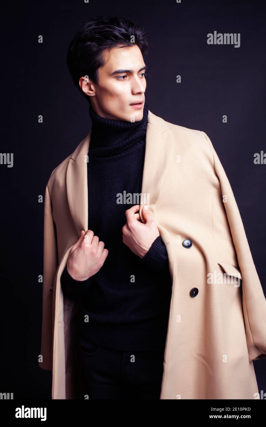 handsome asian fashion looking man posing in studio on black background ...