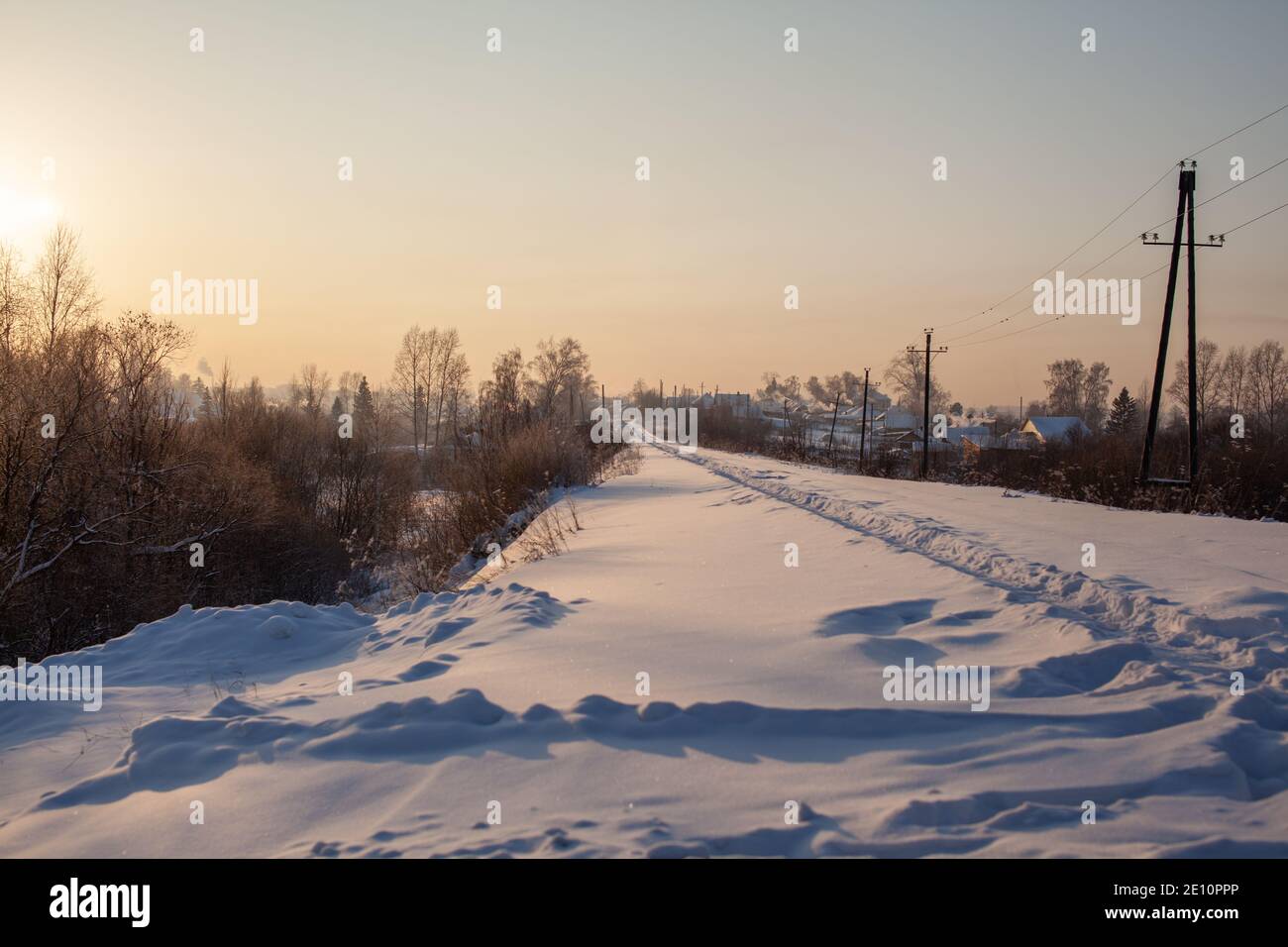 A snow-covered railway and a path trodden by people on it in winter ...