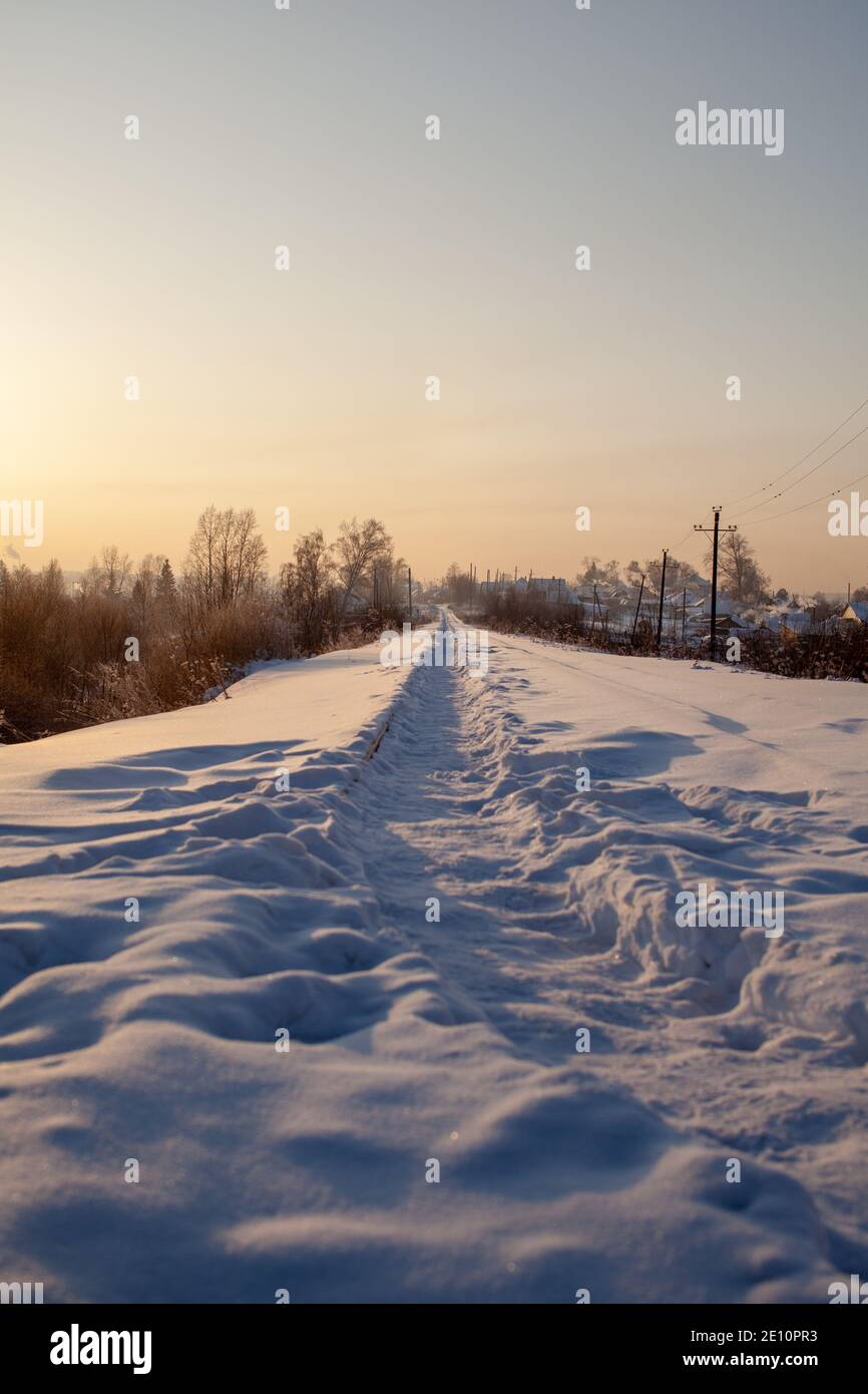 A snow-covered railway and a path trodden by people on it in winter ...