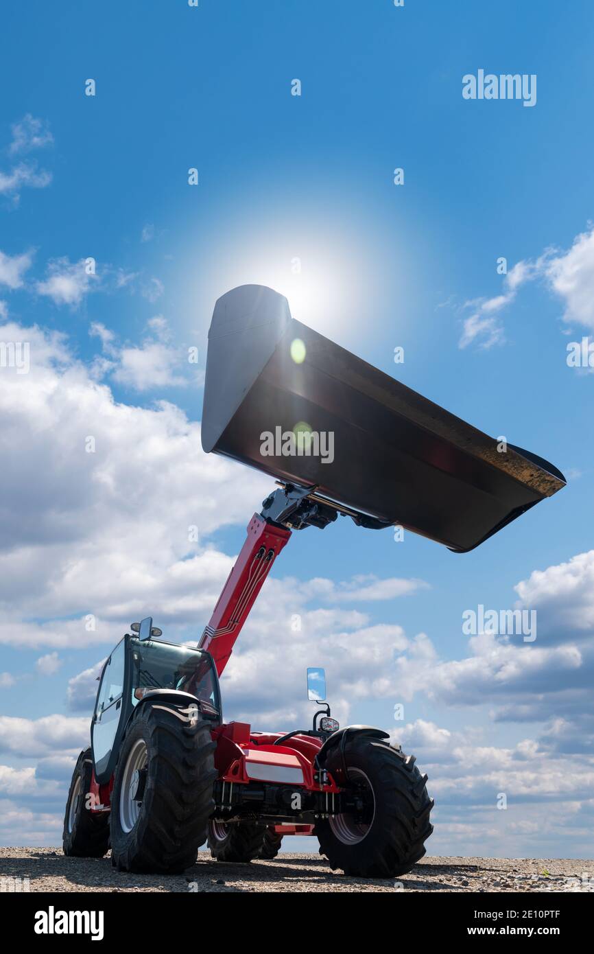 Telescopic loader against the blue sky Stock Photo - Alamy