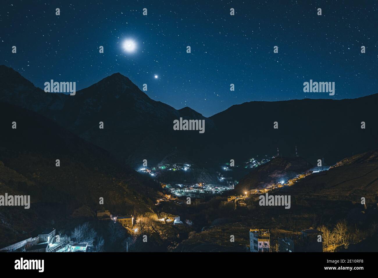 Night sky scene with the Milky Way and stars above Imlil village. Small ...