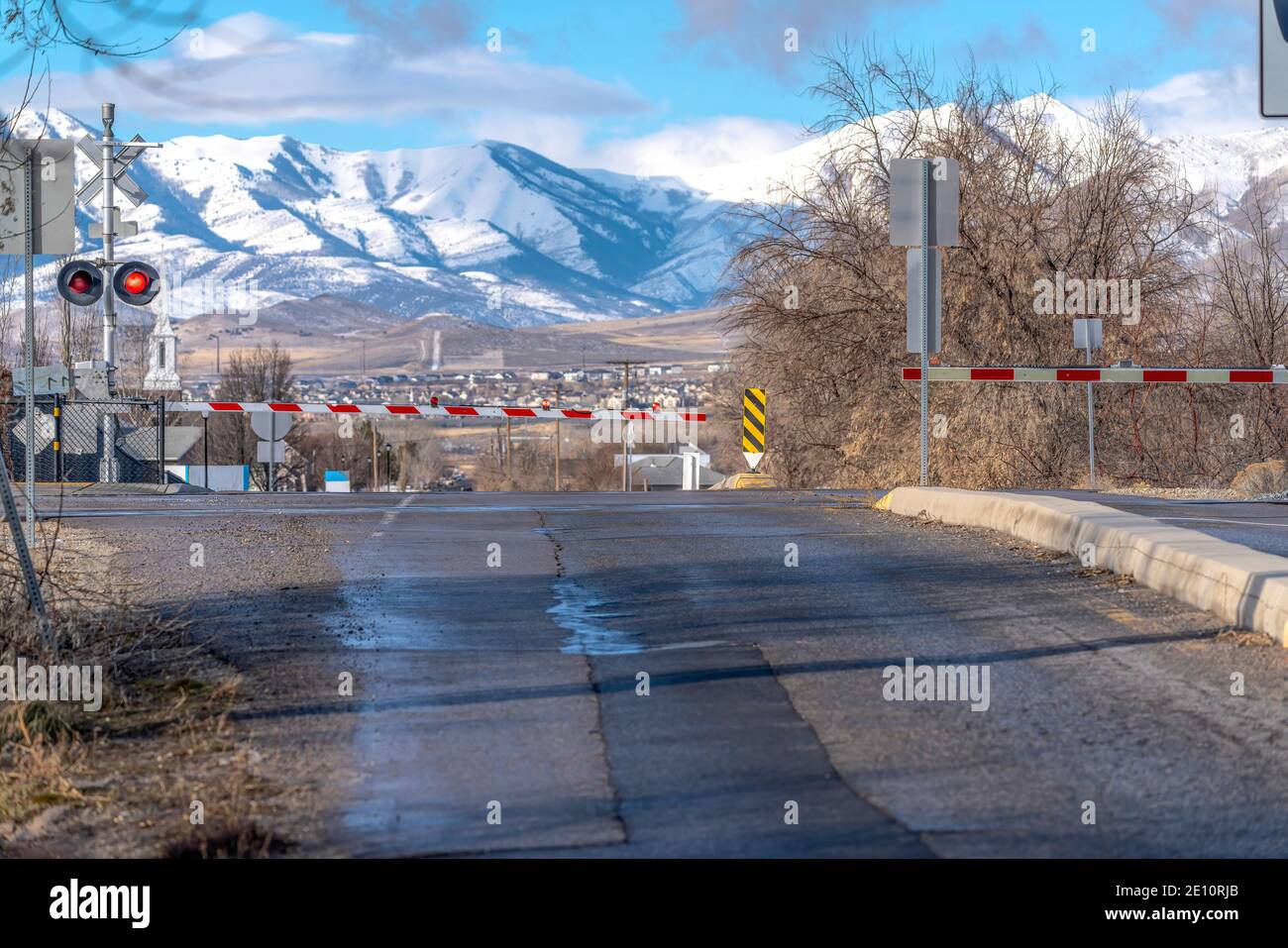 Road and railway intersection at level crossing with red lights signal ...