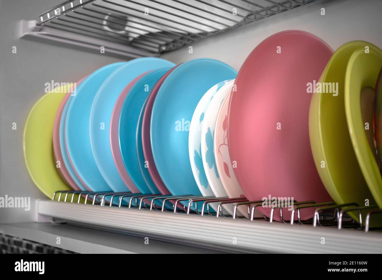 Clean dishes drying on metal racks for dishes on the shelves. Storing ...