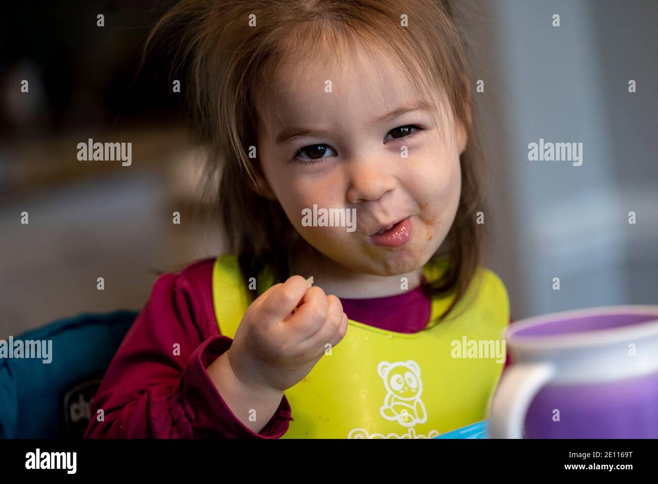 Sweet young child smiles at the table with a slice of pear Stock Photo ...