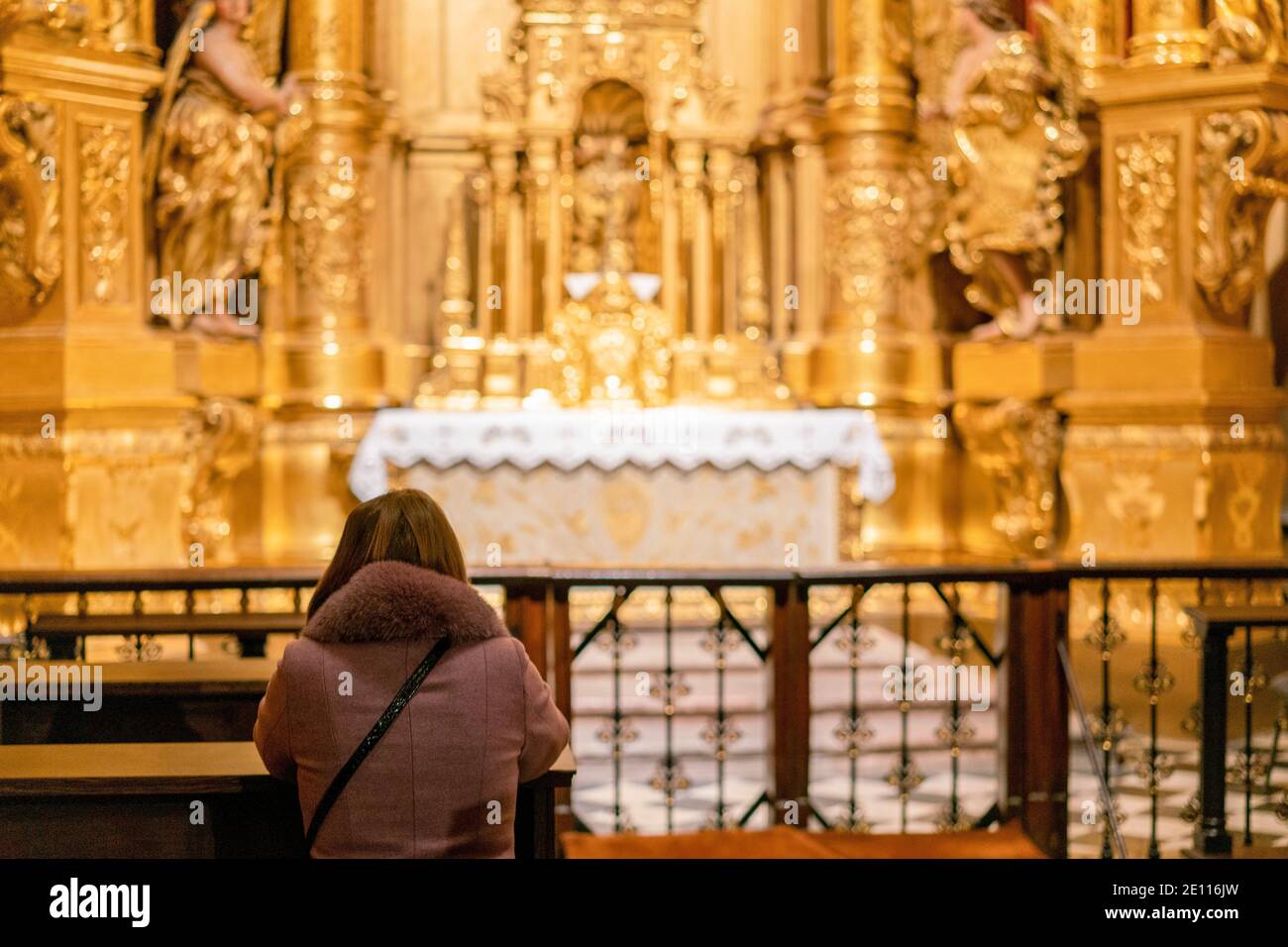 A woman in a temple prays to God. Woman praying in front of altar ...
