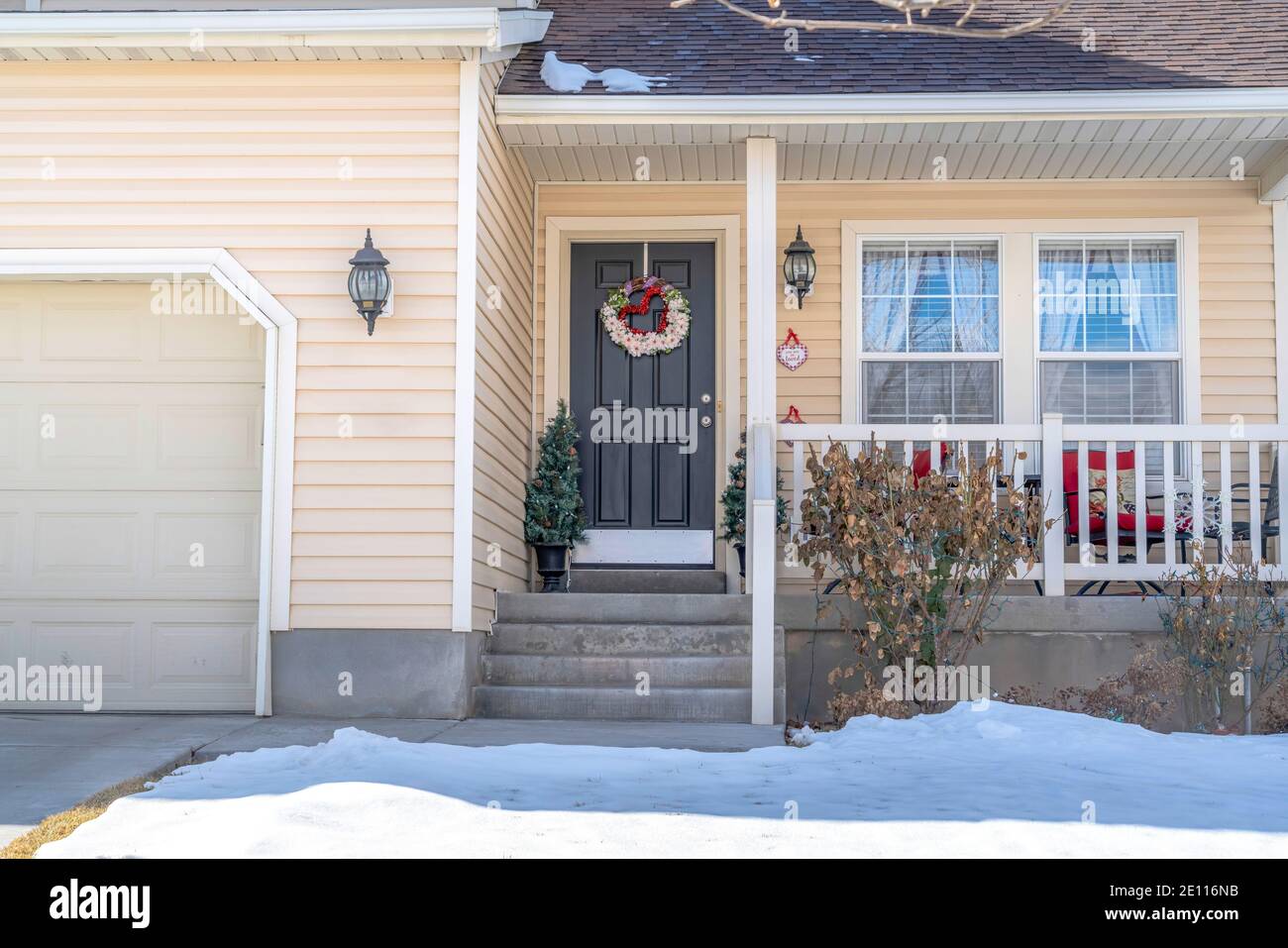 Facade of a cozy home with view of the front porch and door with floral ...
