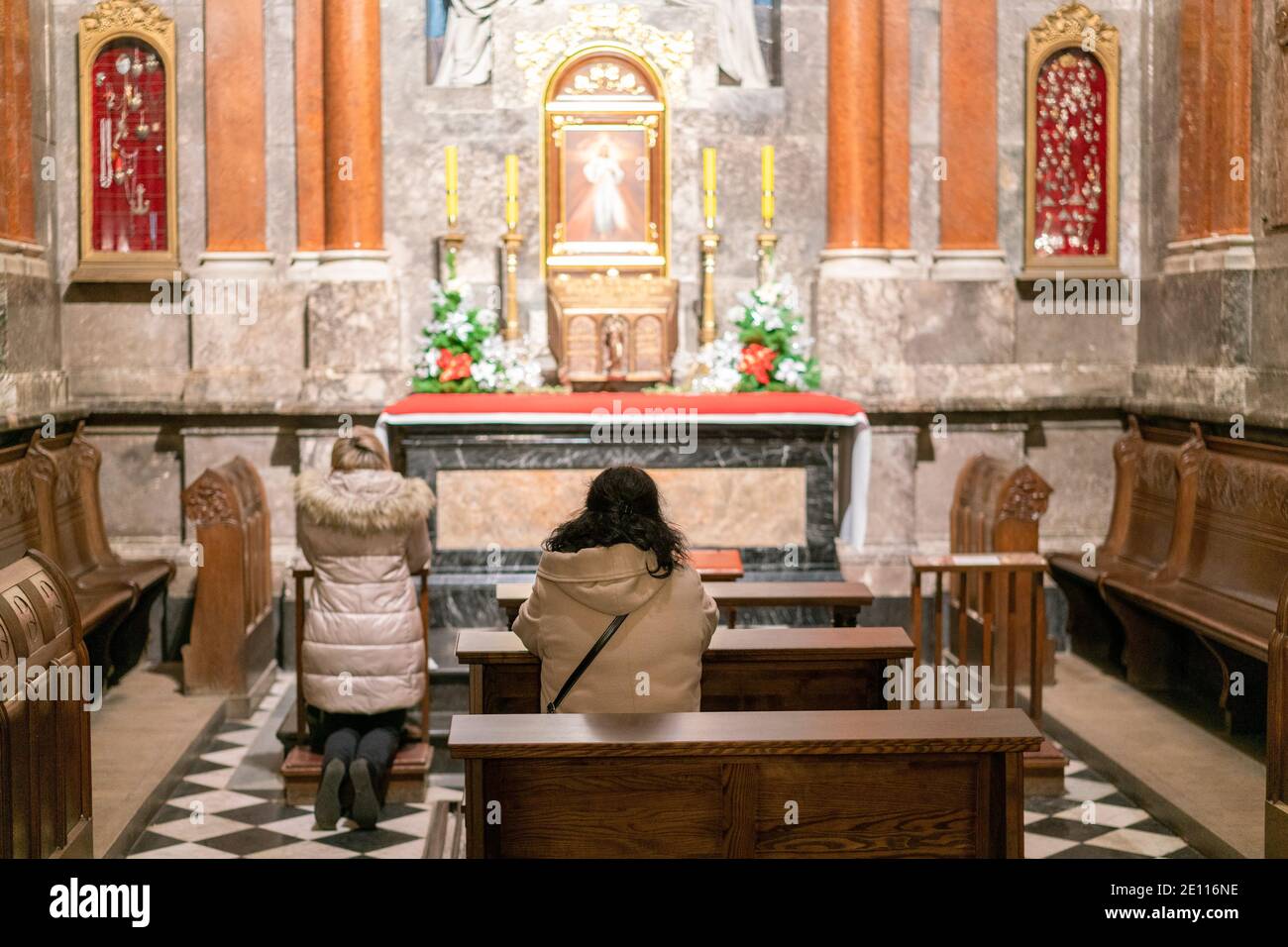A woman in a temple prays to God. Woman praying in front of altar ...