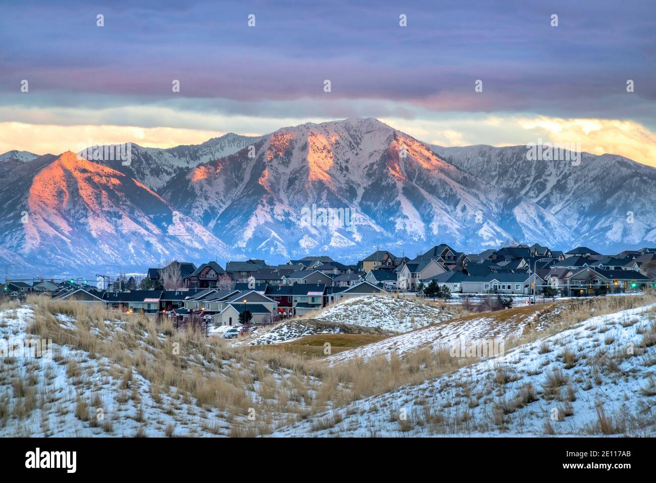 Hilly terrain with snow against valley houses against beautiful snowy ...