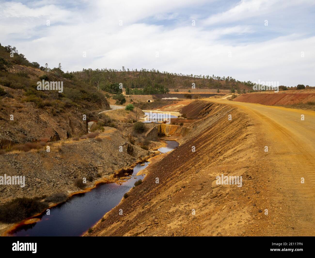 Dirt road aside a polluted water channel in Minas de São Domingos Stock ...