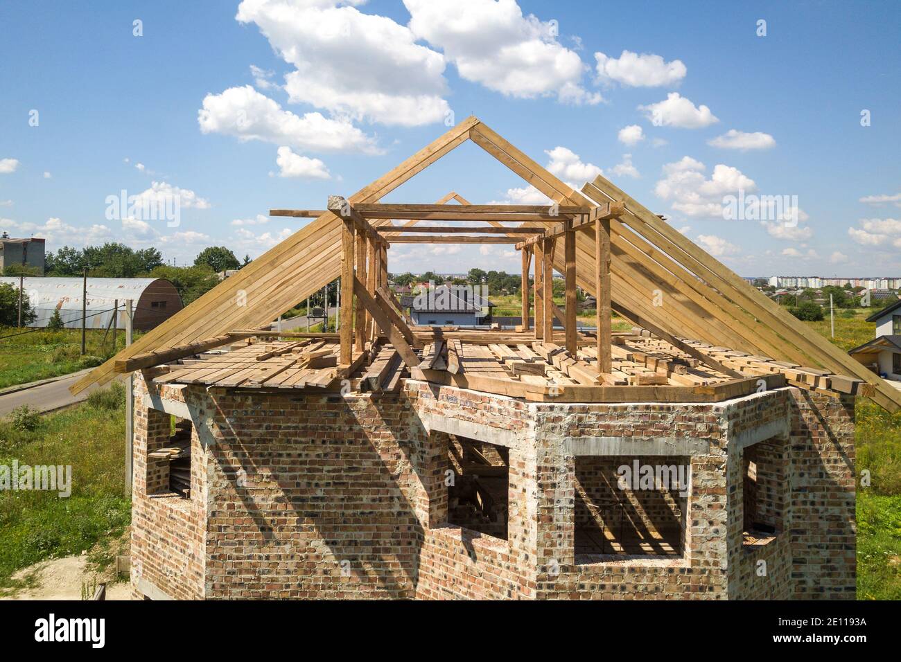 Aerial view of unfinished house with wooden roof frame structure under ...