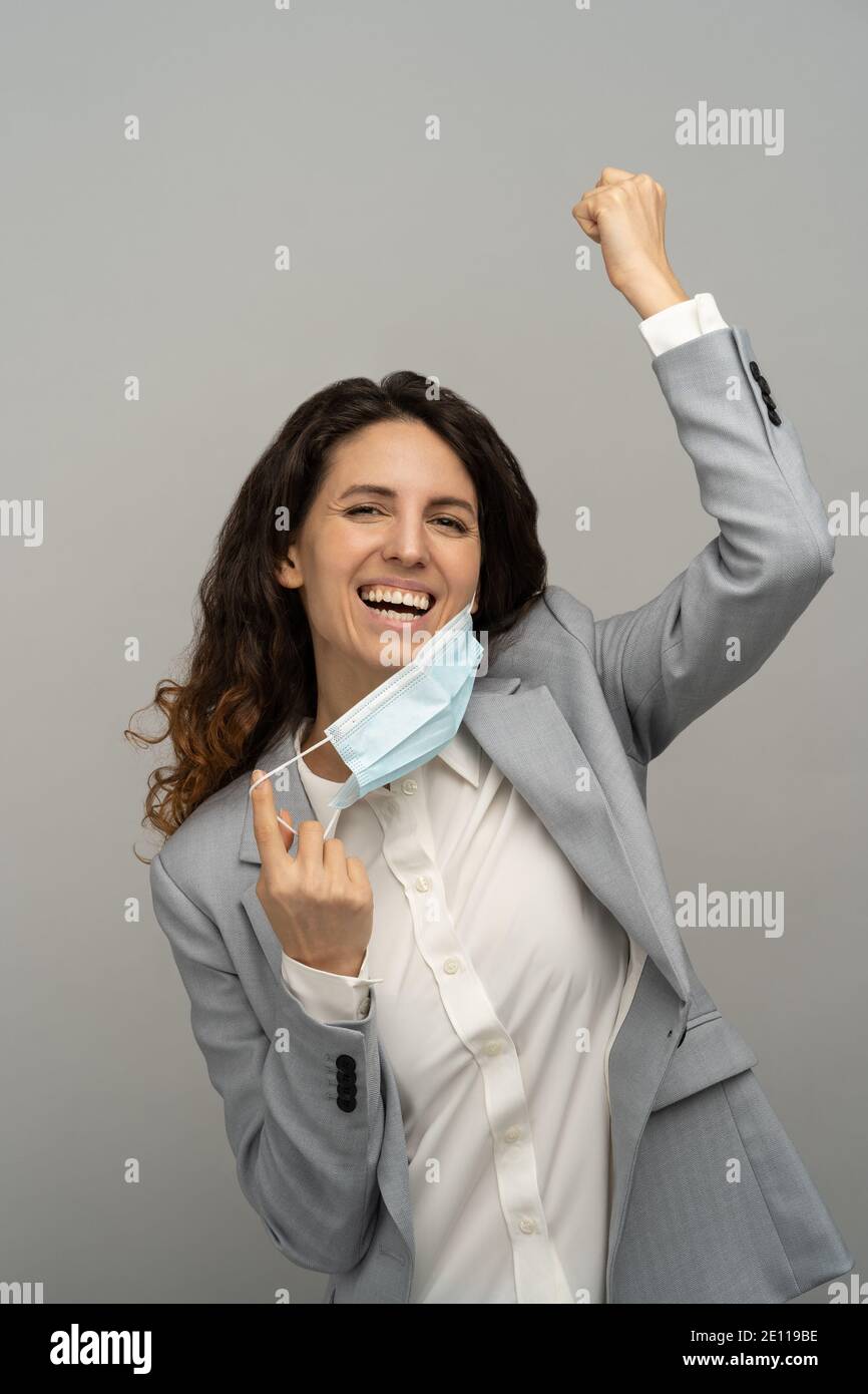 Studio portrait of happy business woman taking off mask from face ...