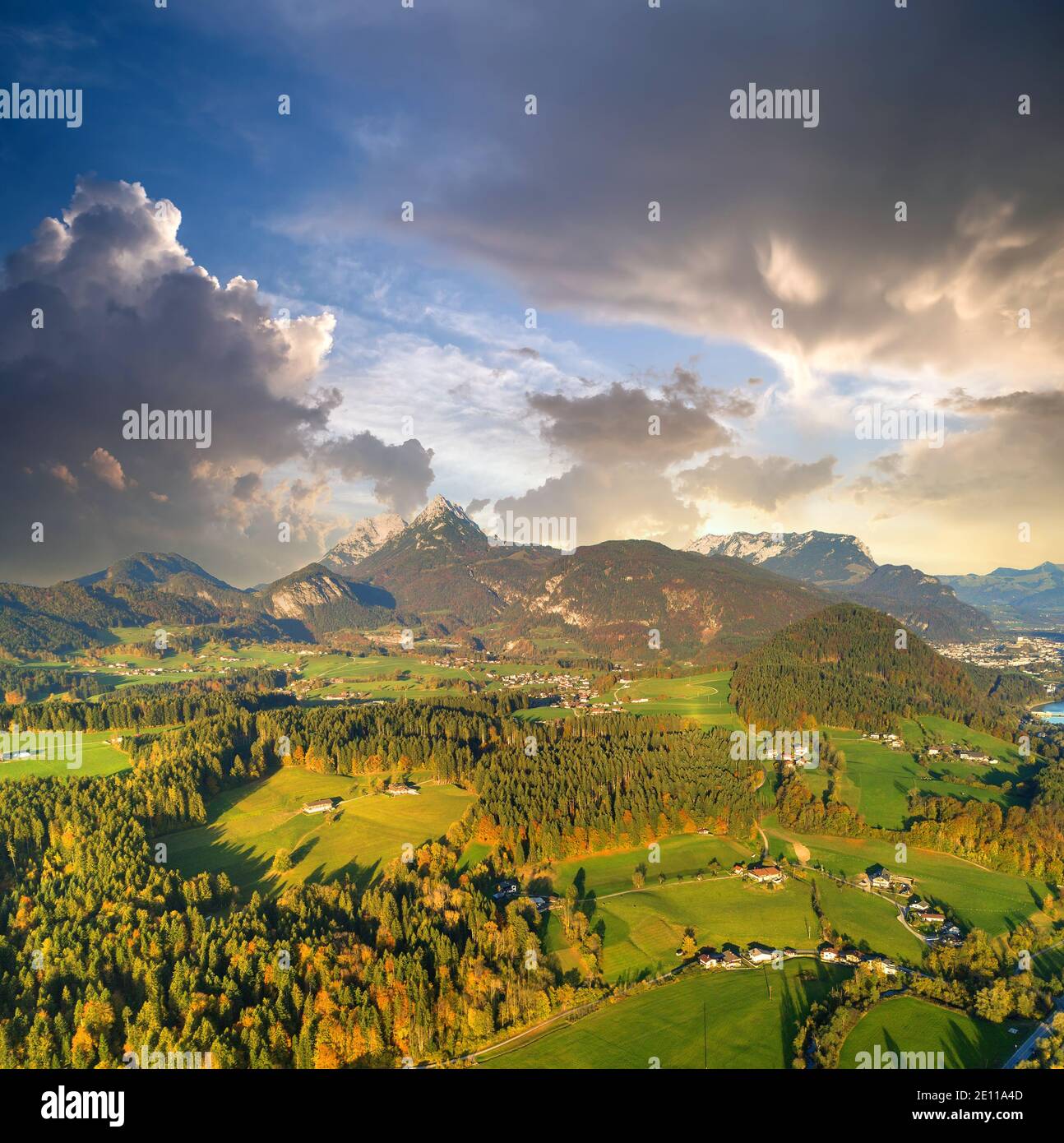 Aerial view of green meadows with villages and forest in austrian Alps ...