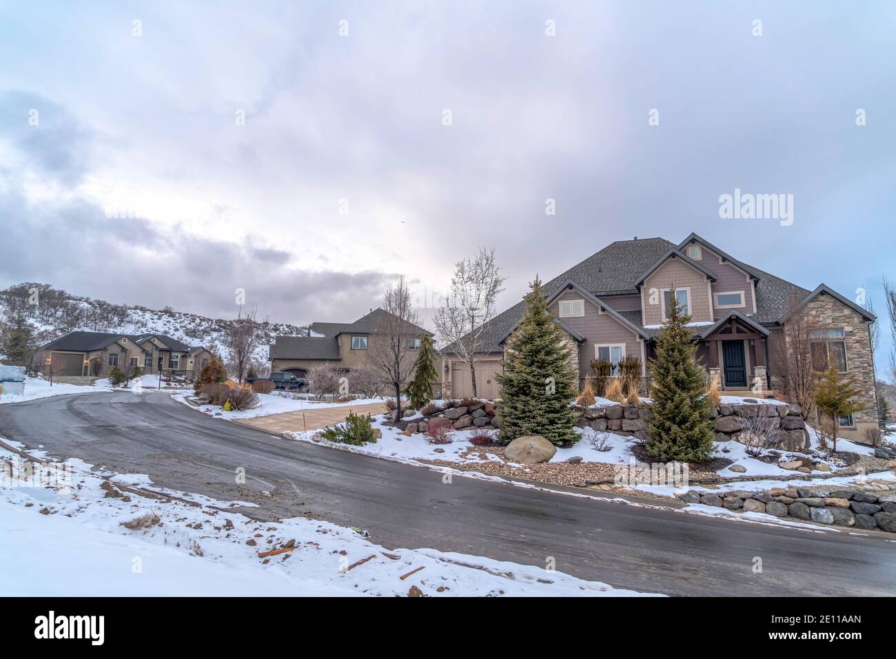 Road along houses on a neighborhood nestled on a snow covered mountain ...