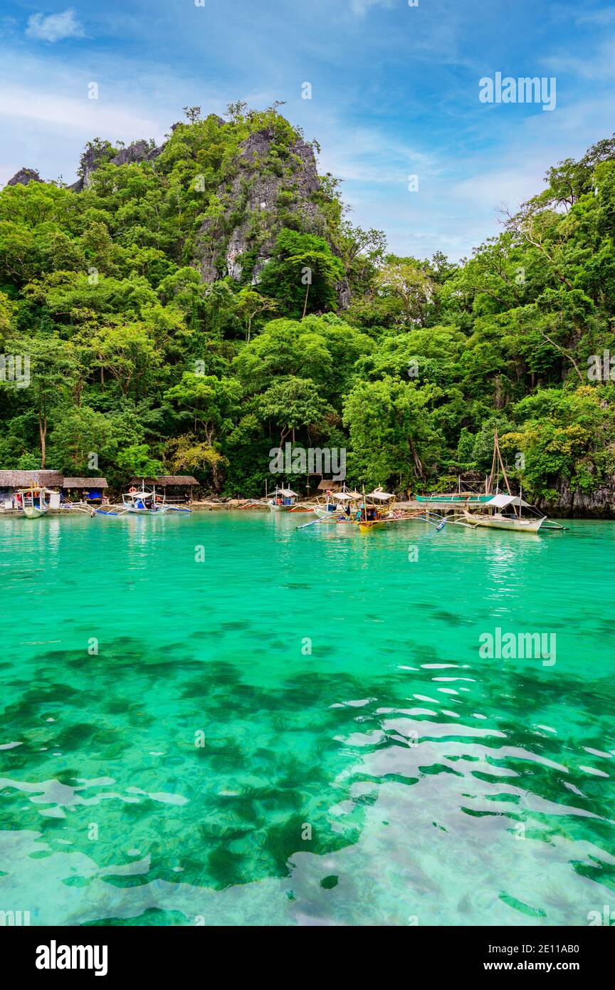 Blue crystal water in paradise Bay with boats on the wooden pier at ...