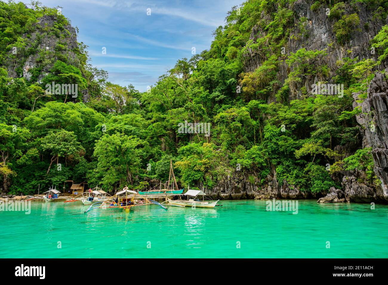 Blue crystal water in paradise Bay with boats on the wooden pier at ...