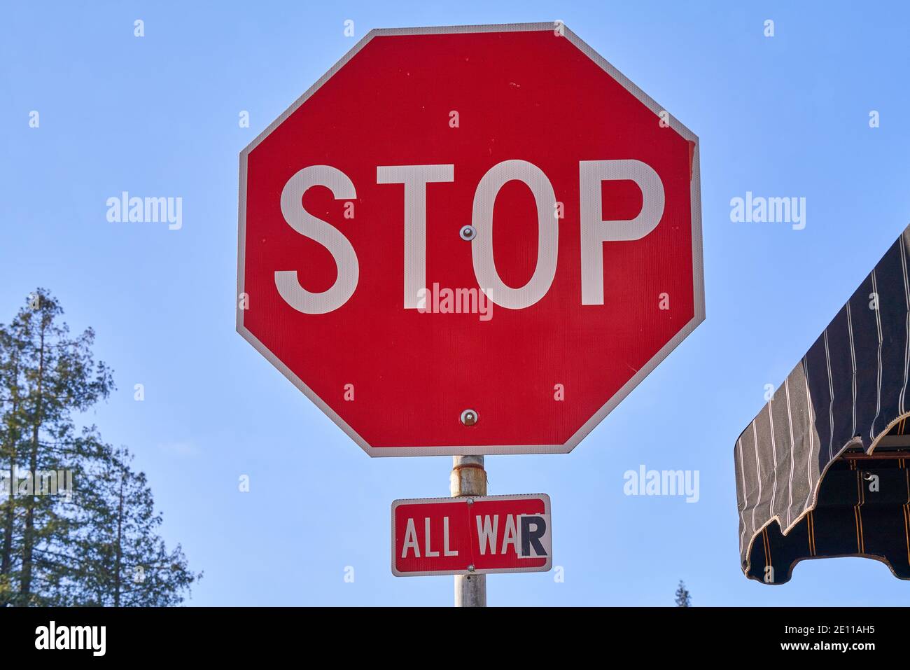STOP ALL WAY road sign, with sticker changing it to STOP ALL WAR, at an ...