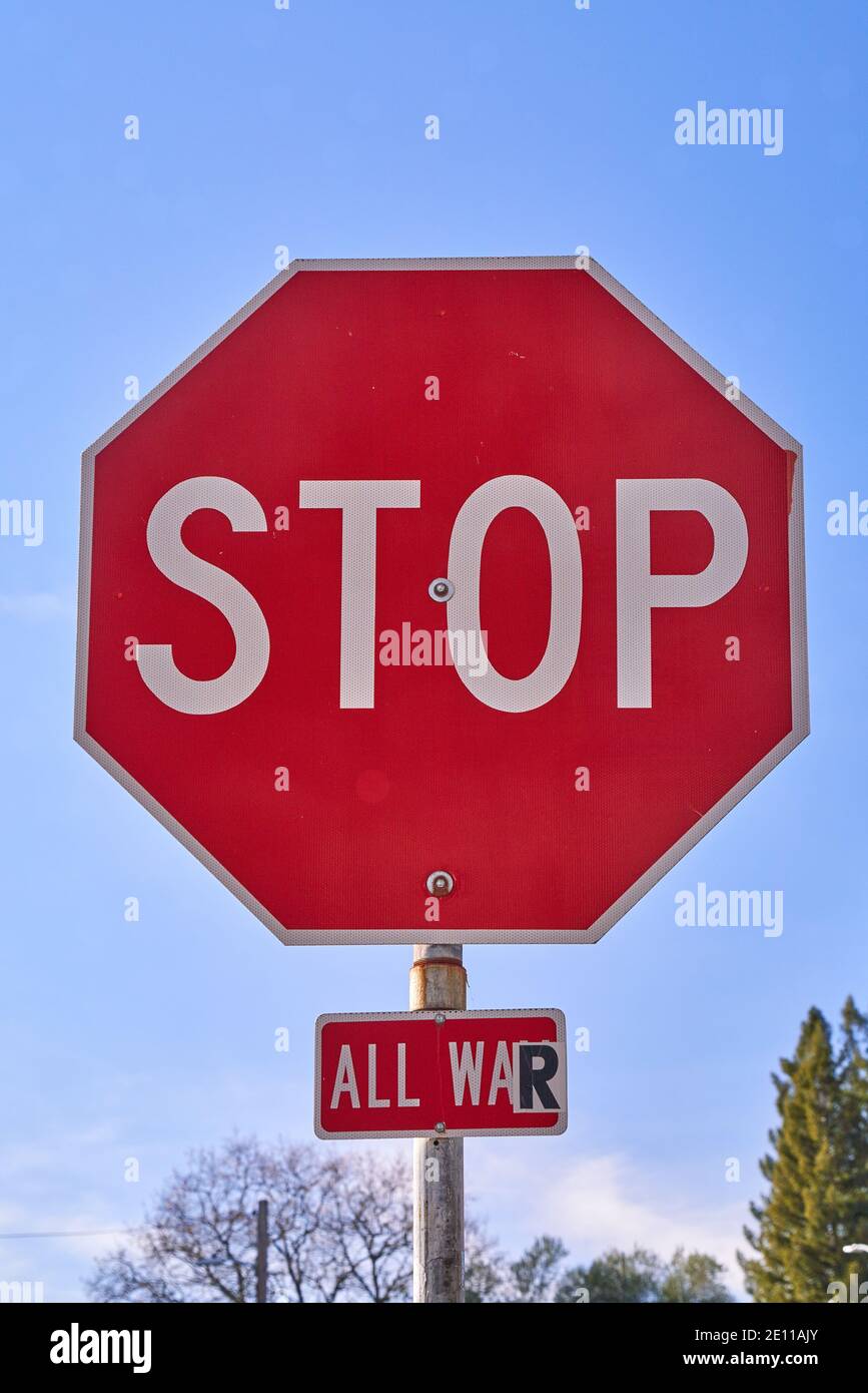 STOP ALL WAY road sign, with sticker changing it to STOP ALL WAR, at an ...
