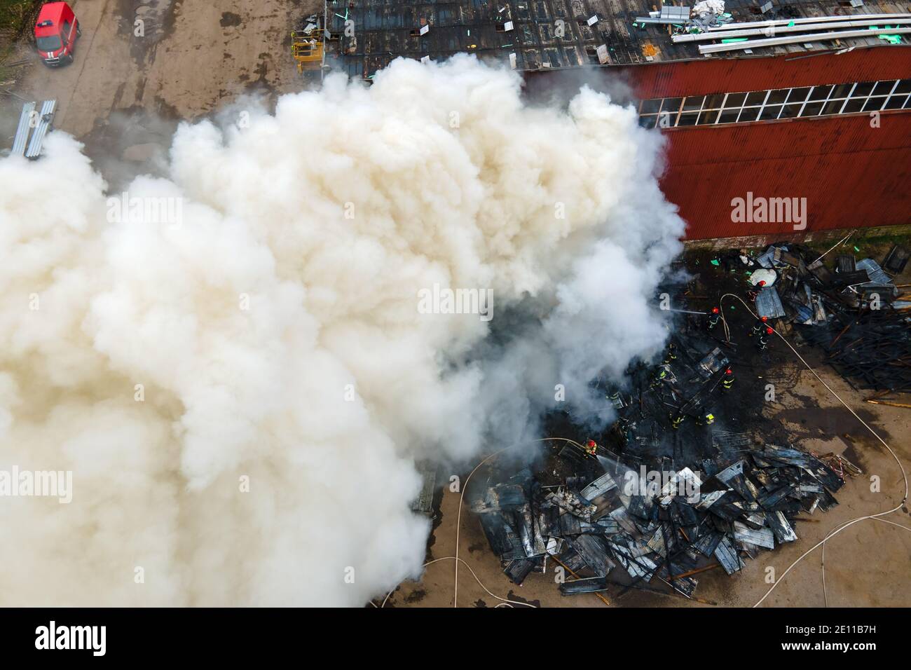 Aerial view of firemen fighting with fire near old factory biulding in ...