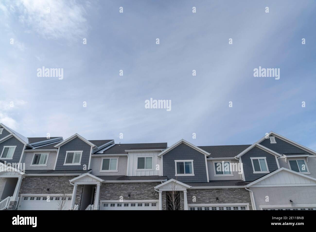 Front view of two storey townhouses in the suburbs against clouds and ...