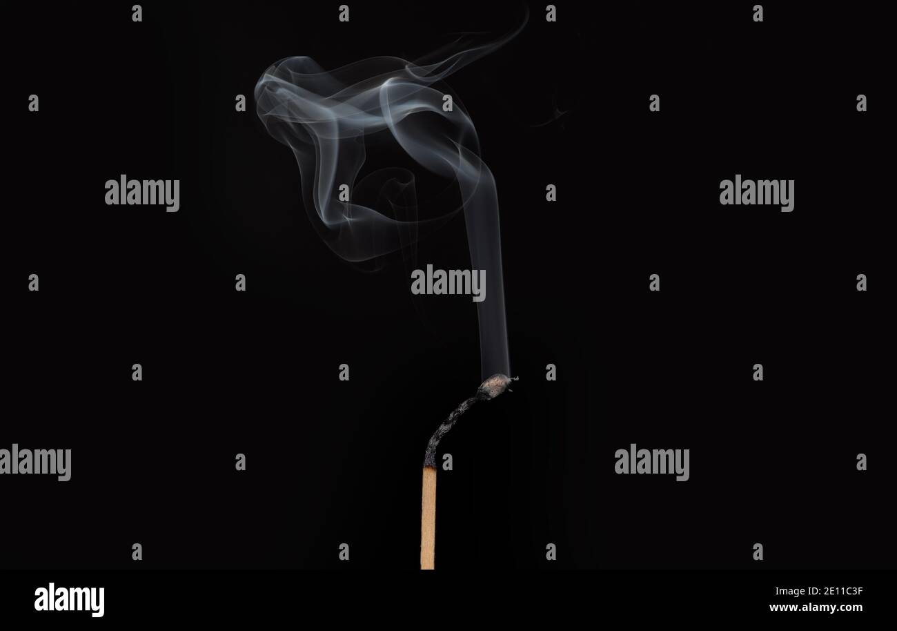 Ignition of match with smoke, isolated on black background. Match just ...