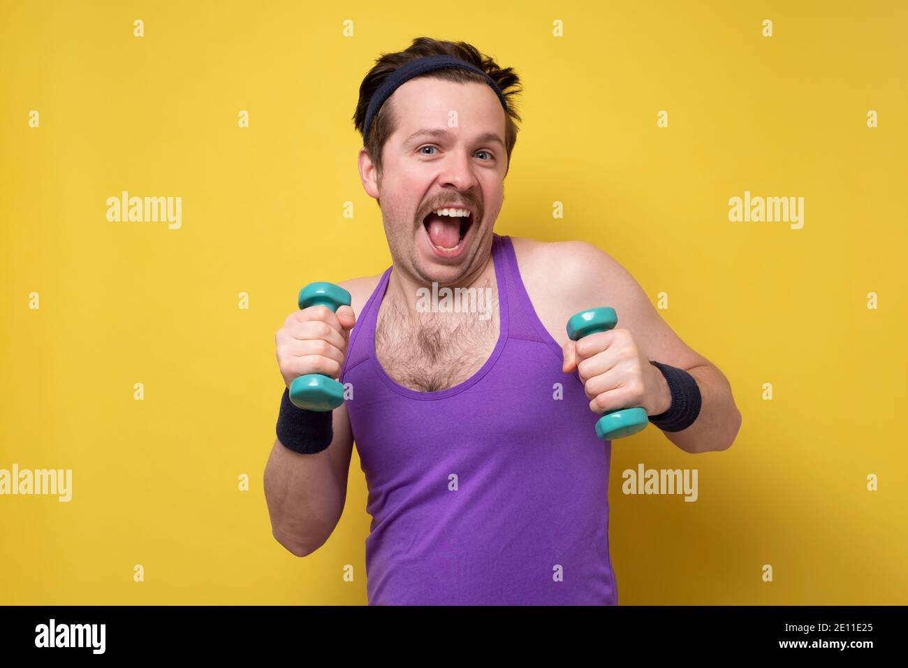 Excited young sporty fitness man doing exercise with dumbbells isolated ...