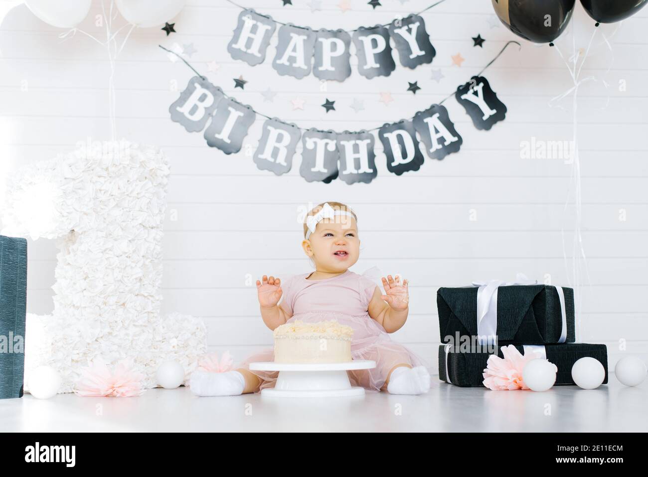 Celebrating the first birthday of a little girl. A child sits near a ...