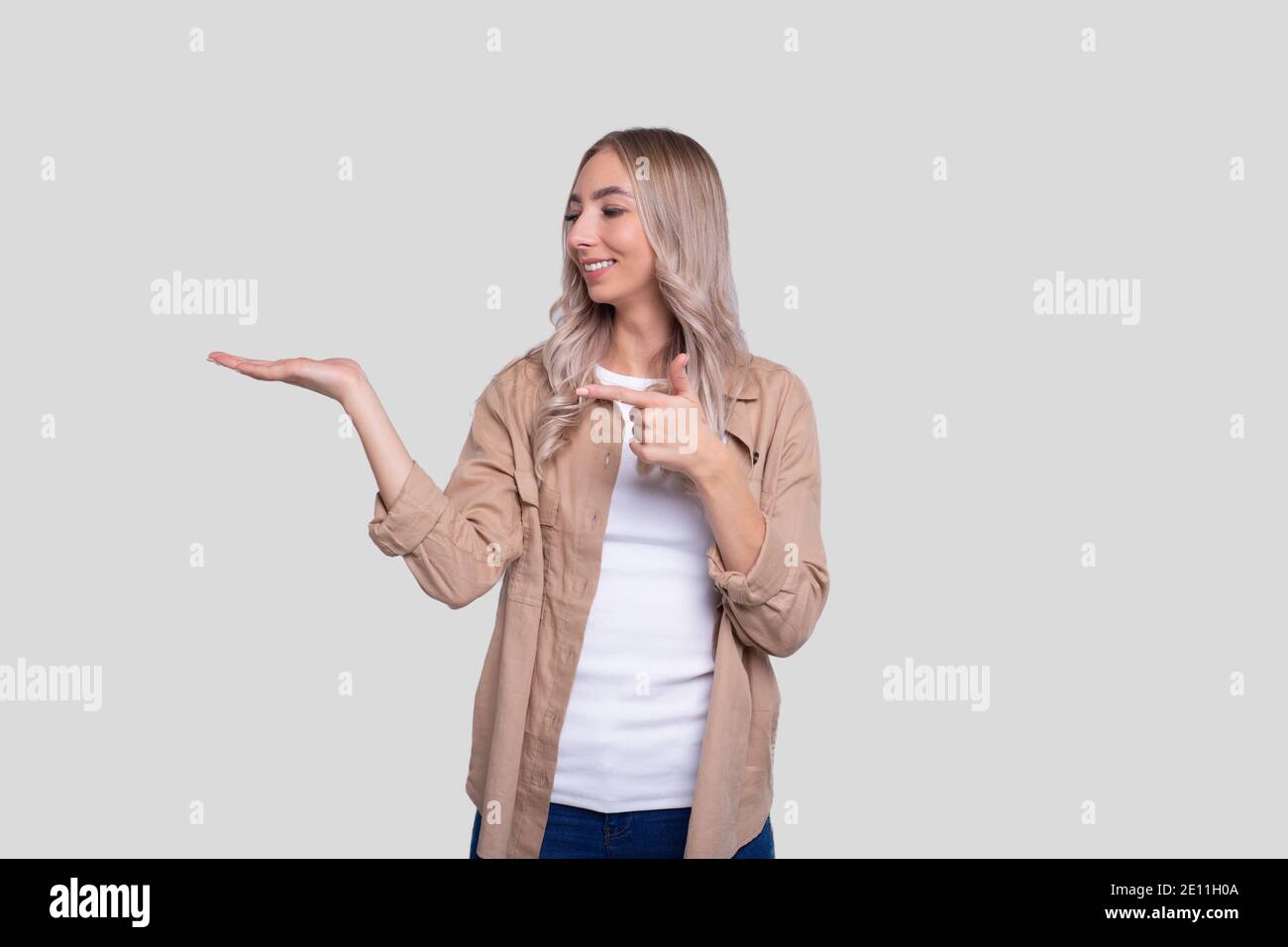 Girl Holding Hand to Side Pointing at Hand Isolated Stock Photo - Alamy