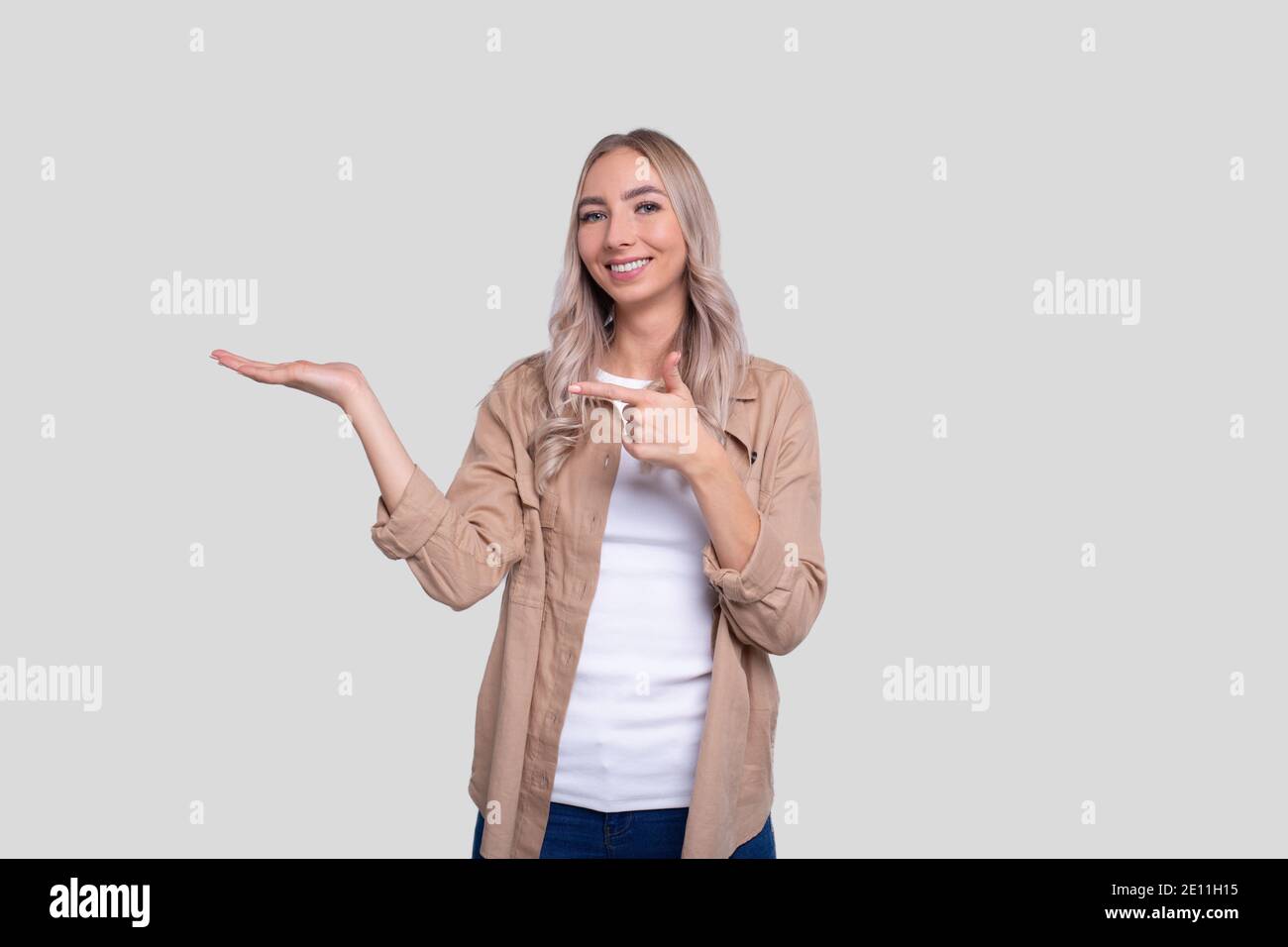 Girl Holding Hand to Side Pointing at Hand Looking in Camera Isolated ...