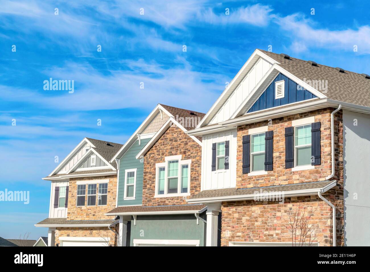 Exterior view of homes with gable roofs stone brick and wooden siding ...